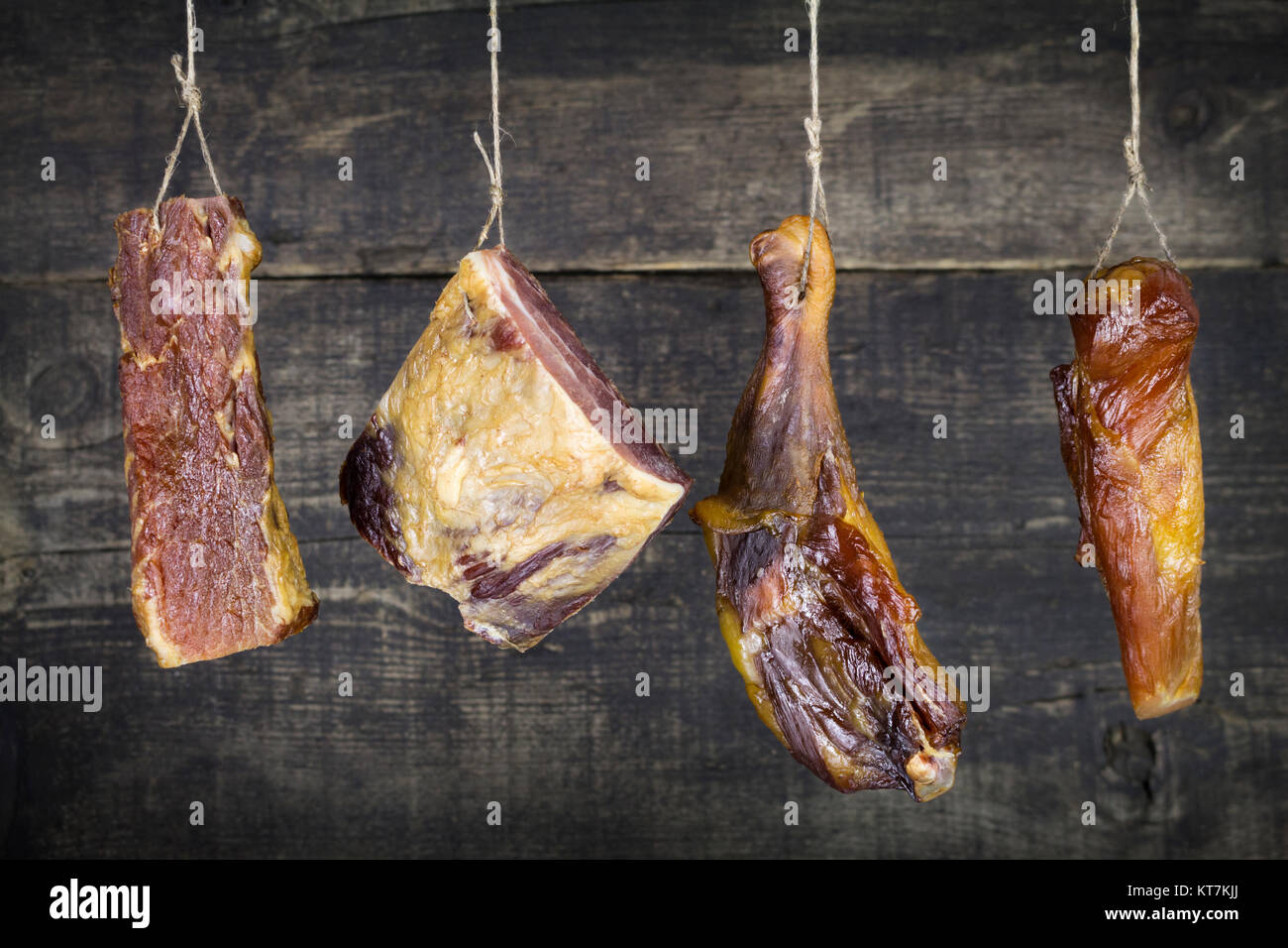Smoked Meat Hanging on the Rope Against Wooden Background Stock Photo ...