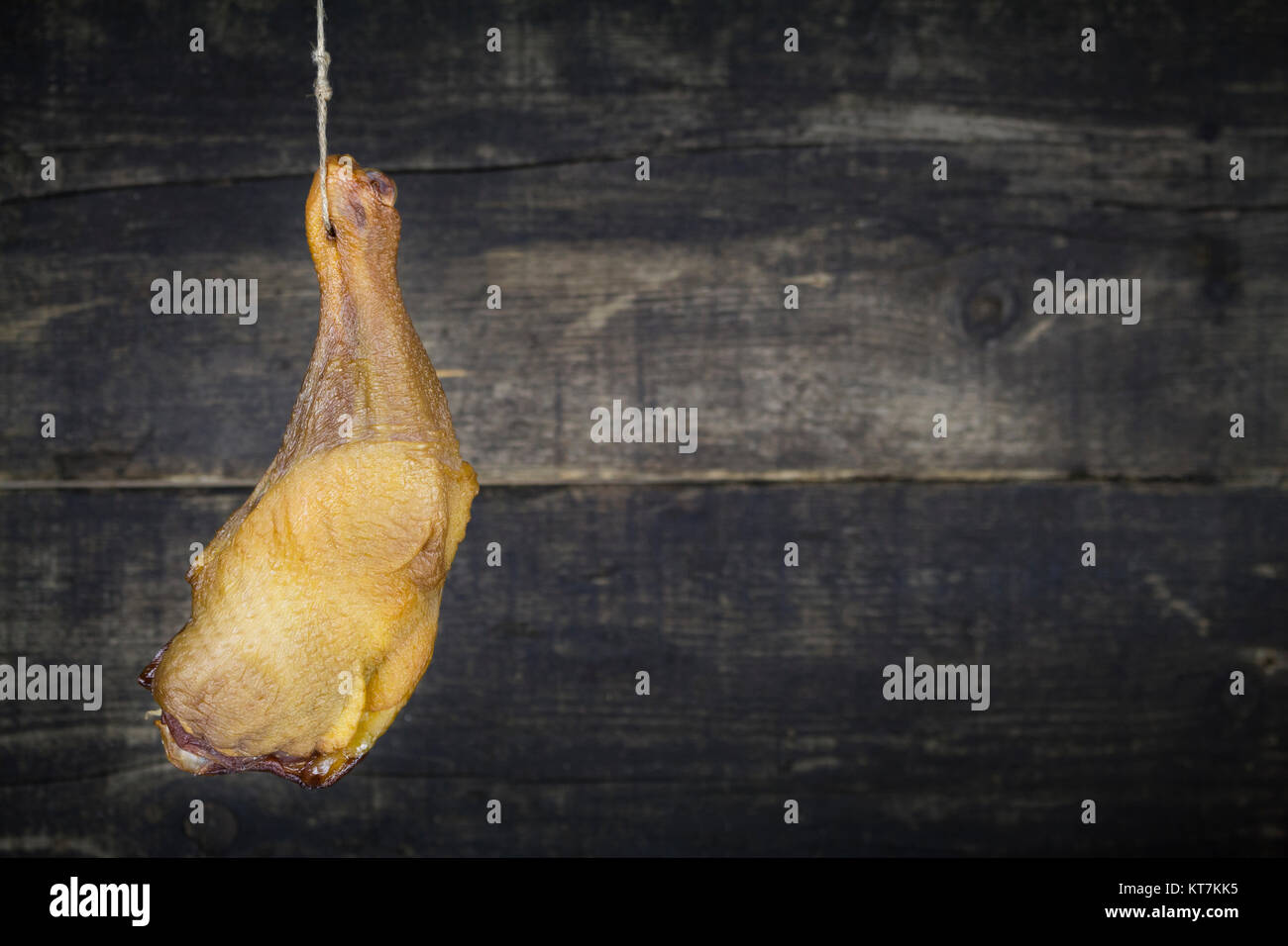 Smoked Chicken Leg Hanging on the Rope Against Wooden Background Stock ...