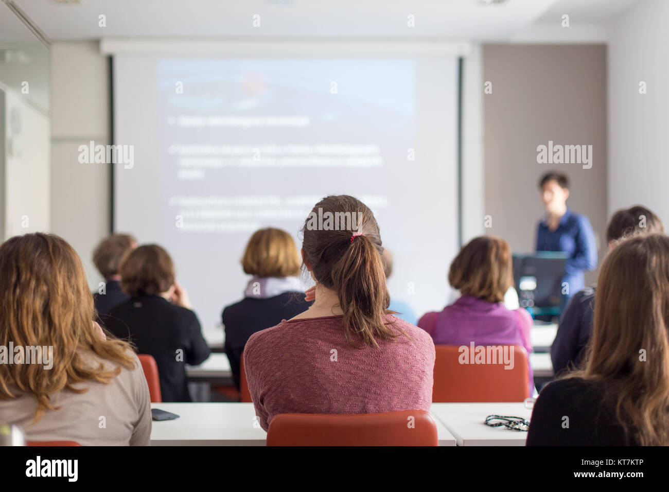 Woman giving presentation in lecture hall at university Stock Photo - Alamy