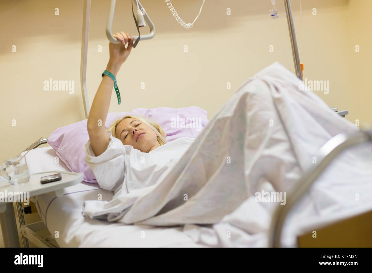 Bedridden female patient recovering after surgery in hospital care ...