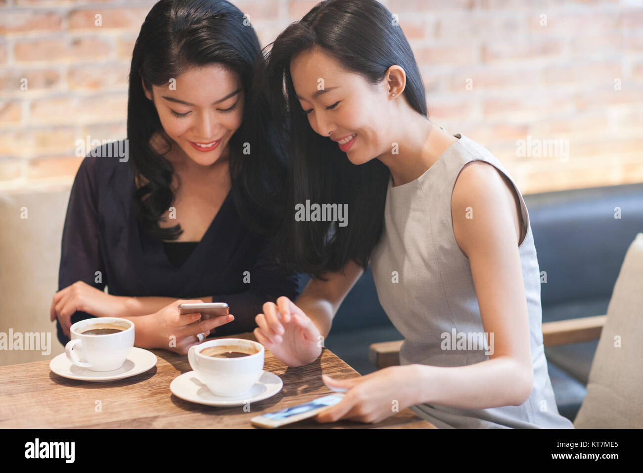 Best female friends drinking coffee in café Stock Photo - Alamy