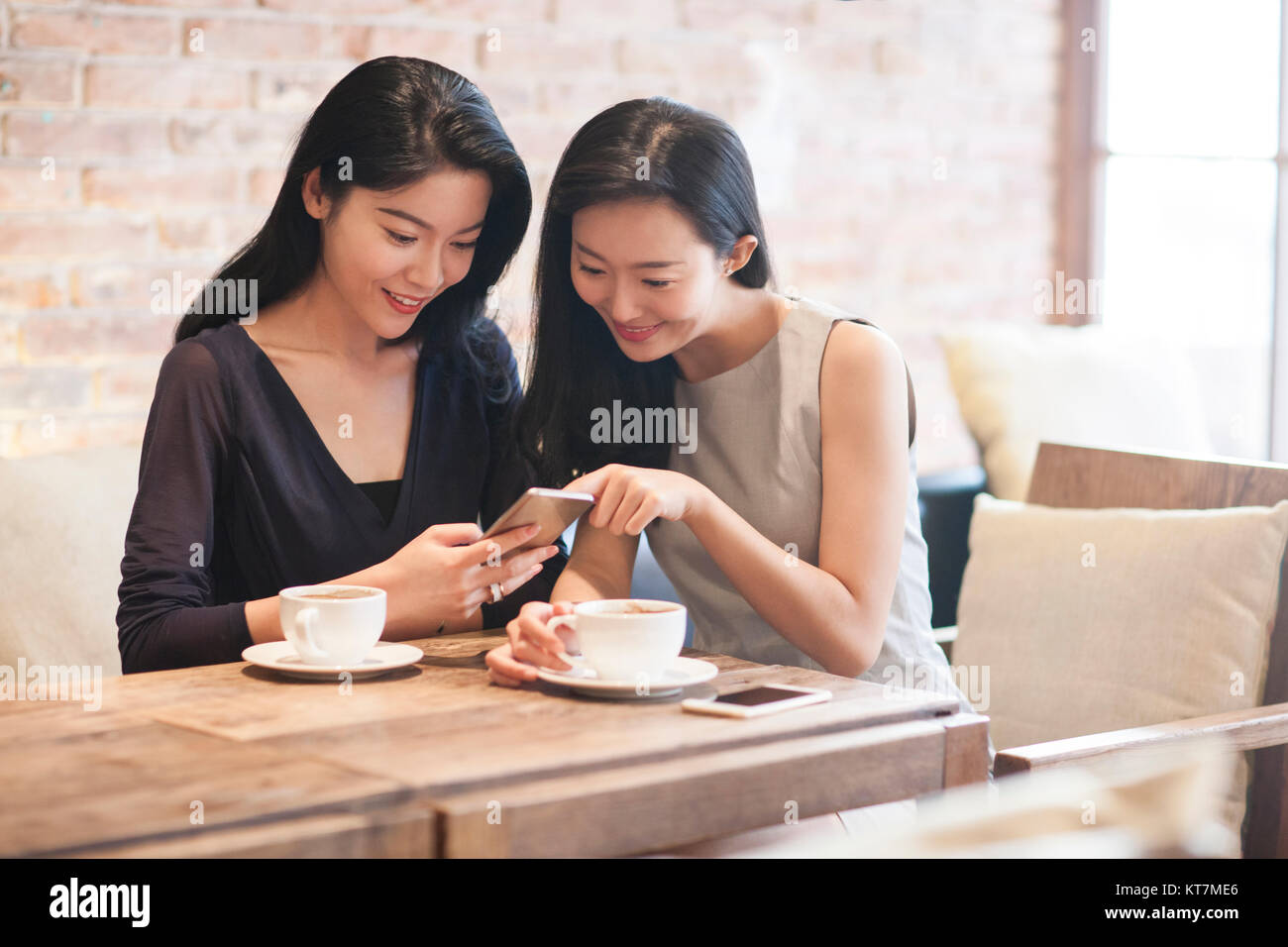 Best female friends drinking coffee in café Stock Photo - Alamy