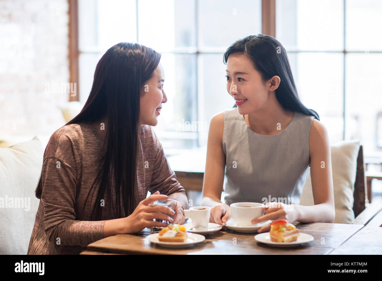 Best female friends drinking coffee in café Stock Photo - Alamy