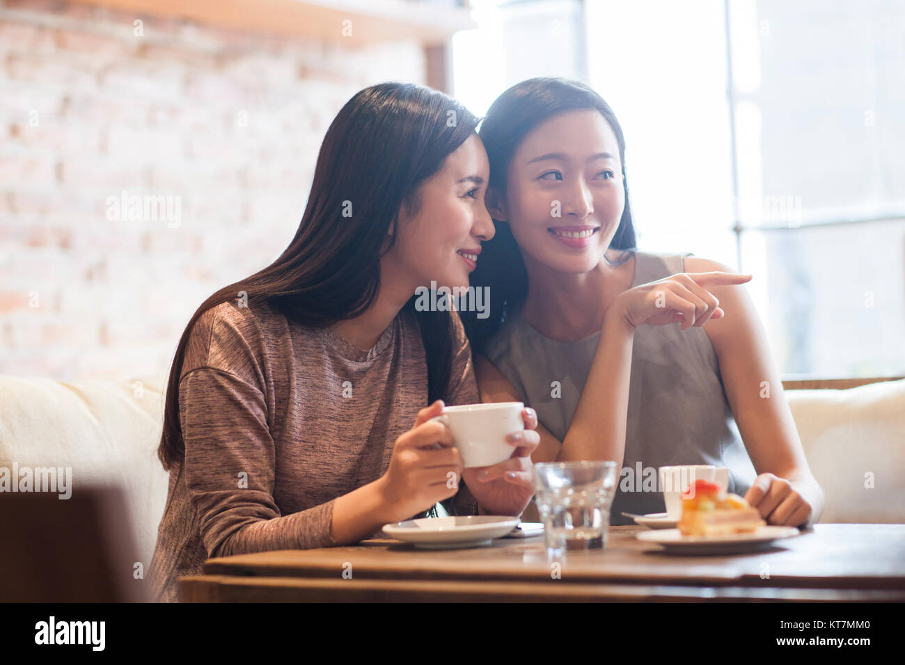 Best female friends drinking coffee in café Stock Photo - Alamy