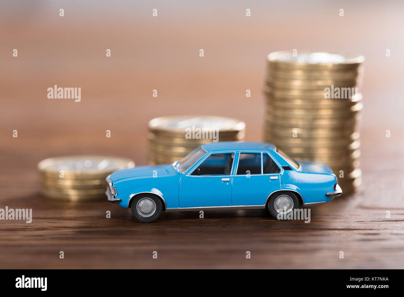 Car Model In Front Of Stacked Coin Stock Photo - Alamy