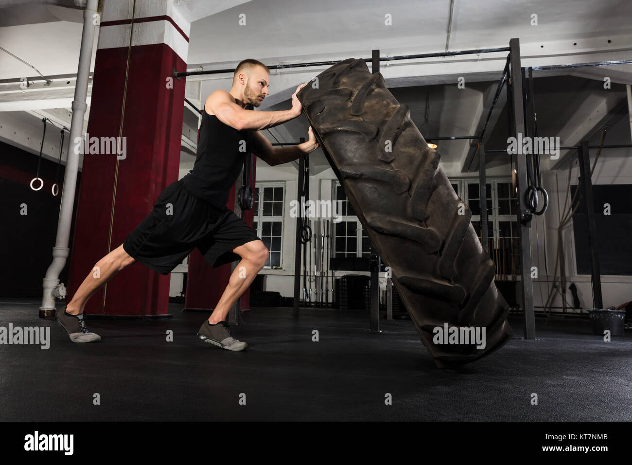 Young Man Pushing Tire Stock Photo - Alamy