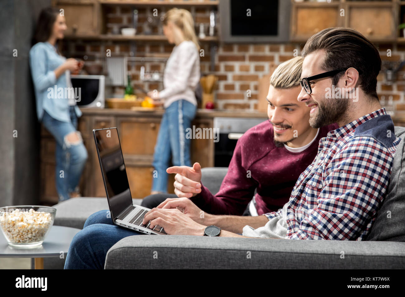 Friends using laptop Stock Photo - Alamy