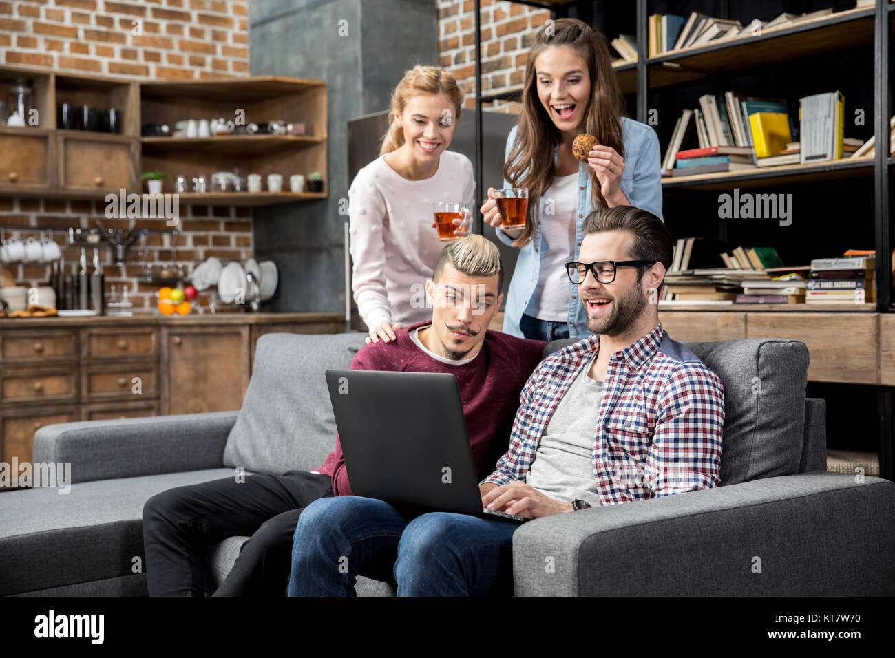 Friends using laptop Stock Photo - Alamy