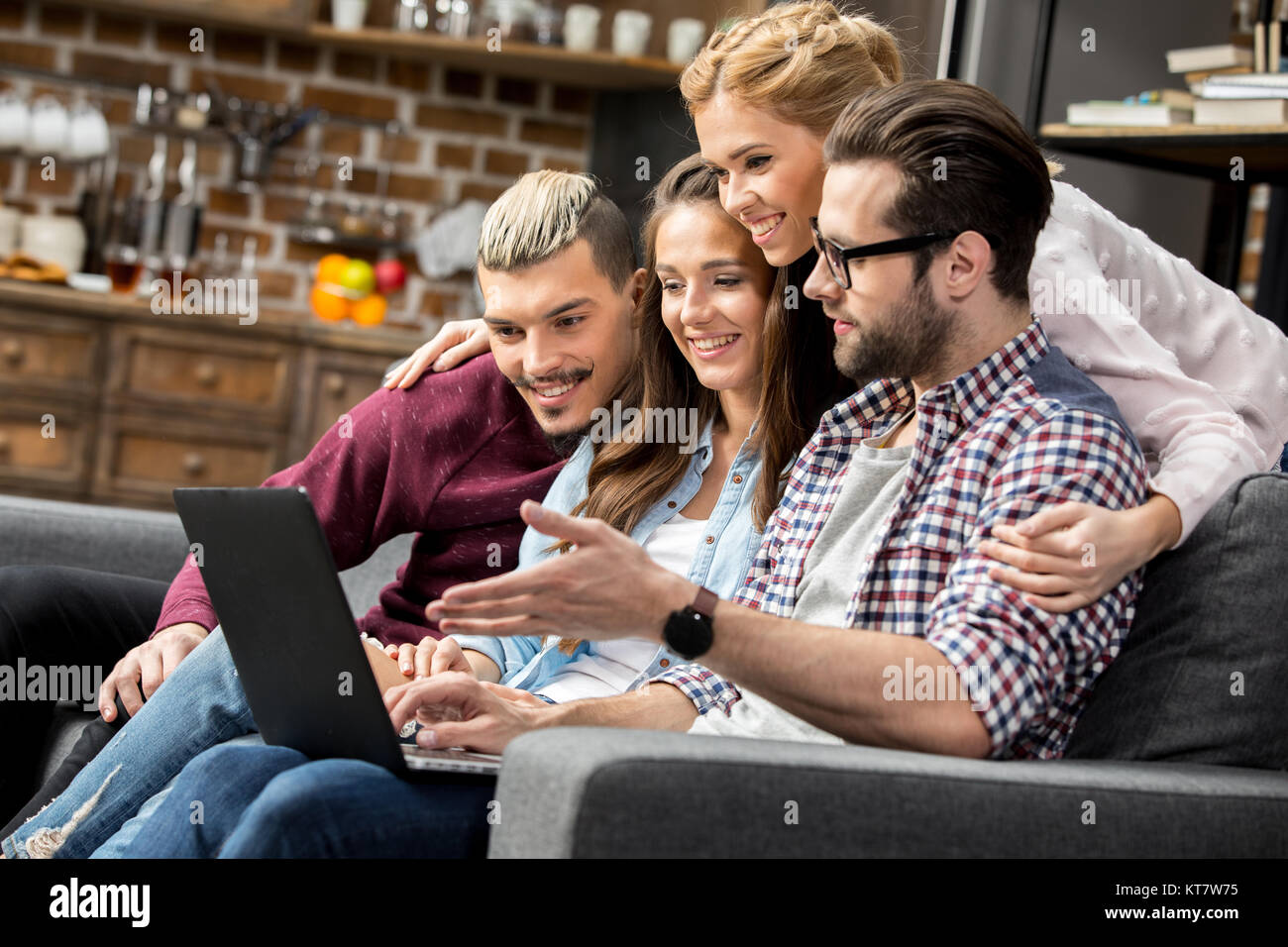 Friends using laptop Stock Photo - Alamy