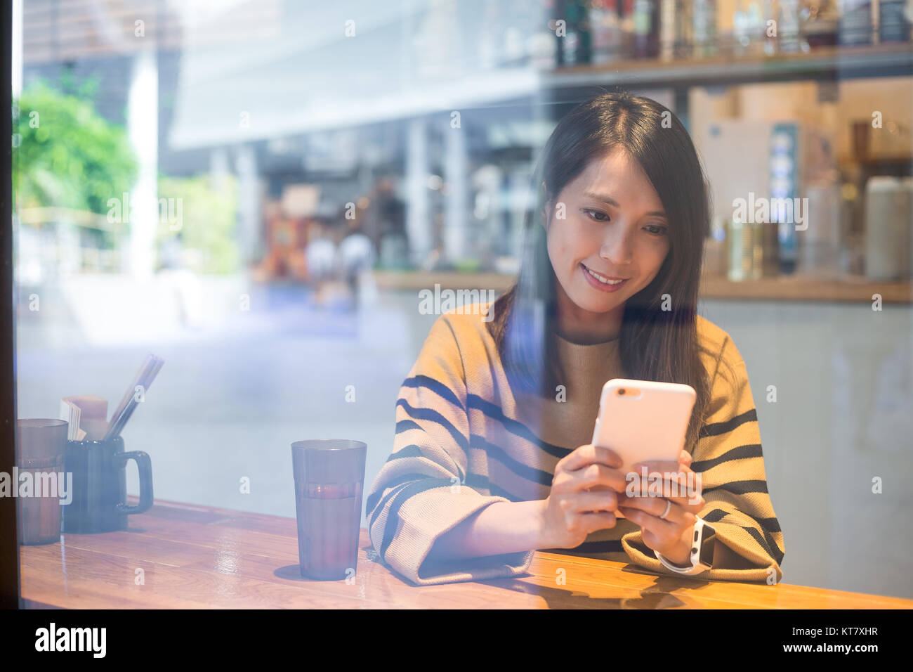 Woman using mobile phone in coffee shop Stock Photo - Alamy