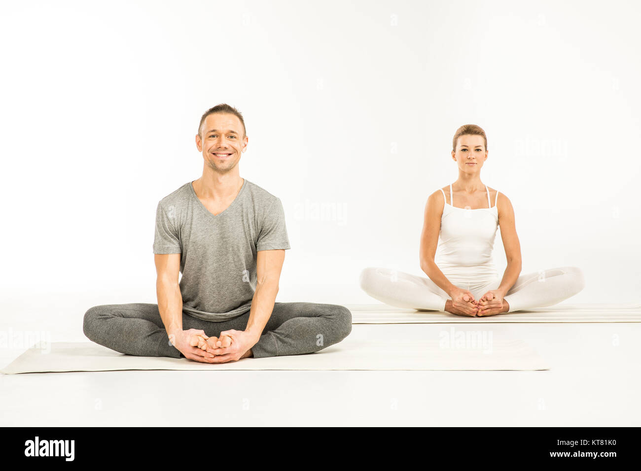 Couple sitting in lotus position Stock Photo - Alamy
