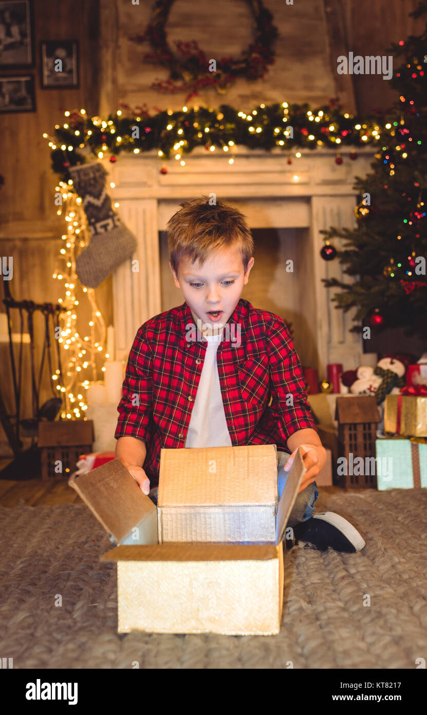 Boy opening christmas present Stock Photo - Alamy