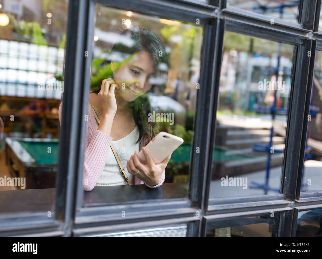 Window reflection of woman use of mobile phone Stock Photo - Alamy