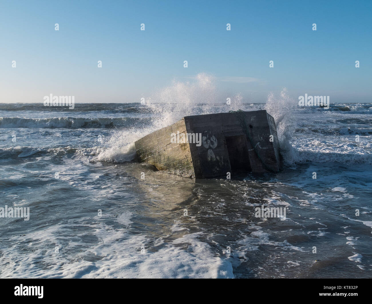 Concrete Bunker on the beach as the water spray from the waves. The ...