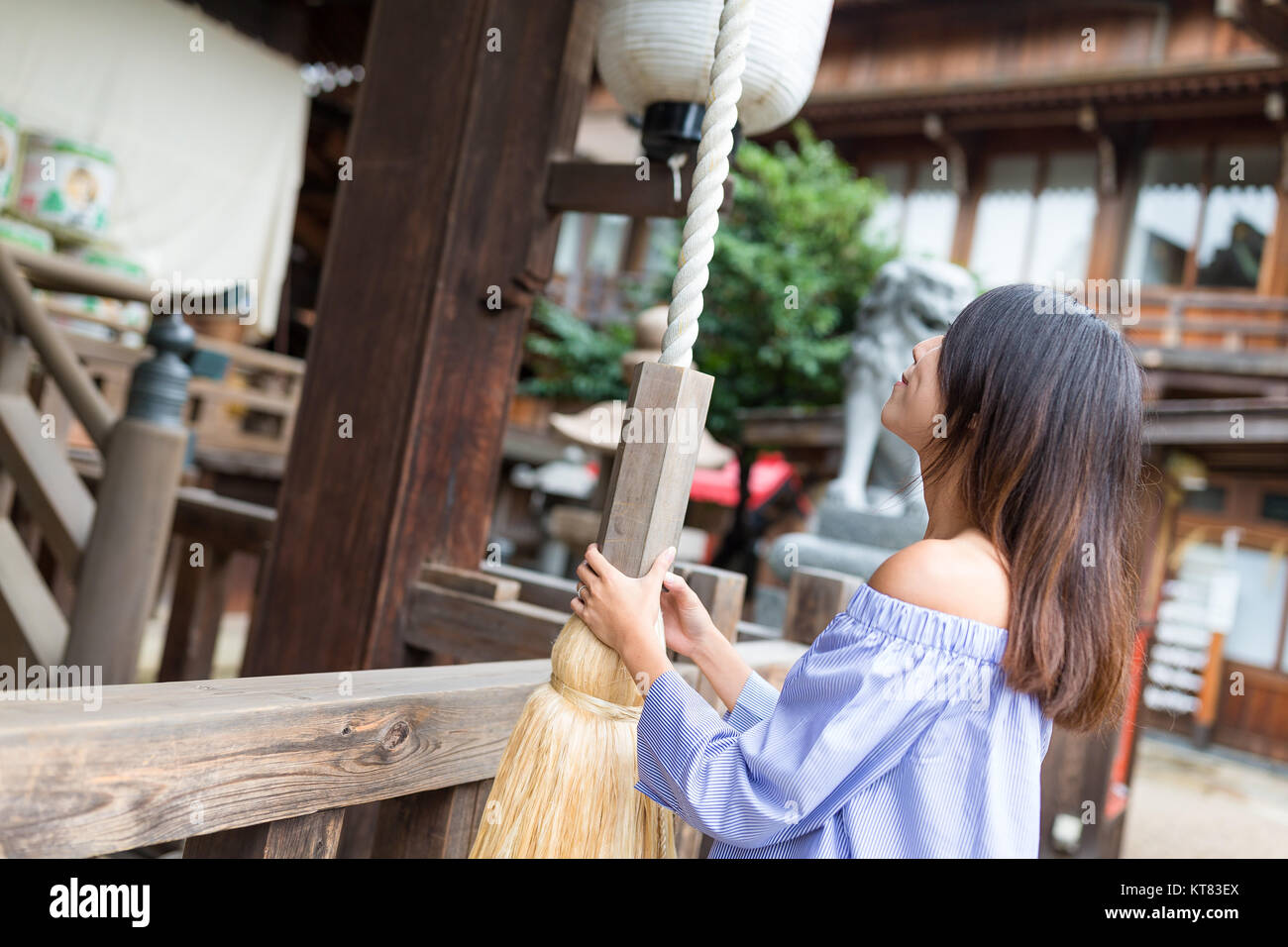 Woman ringing the bell in japanese temple Stock Photo - Alamy