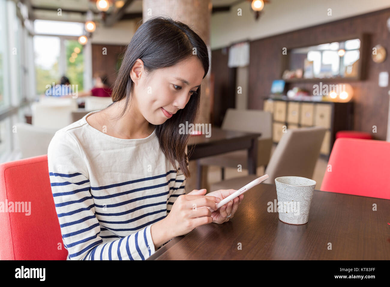 Woman using mobile phone in coffee shop Stock Photo - Alamy