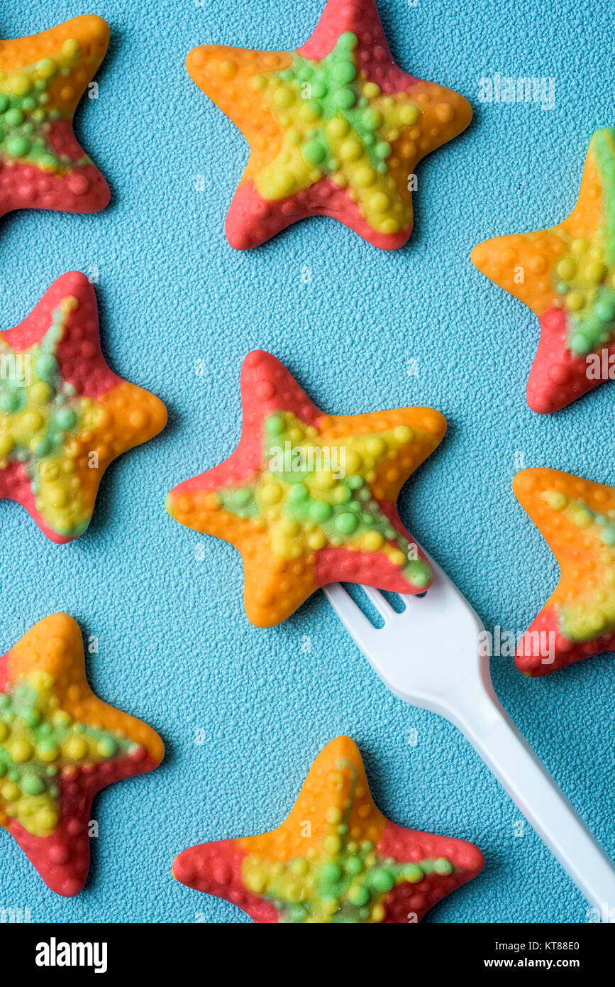 high angle view of some starfish-shaped gummy candies and a plastic ...