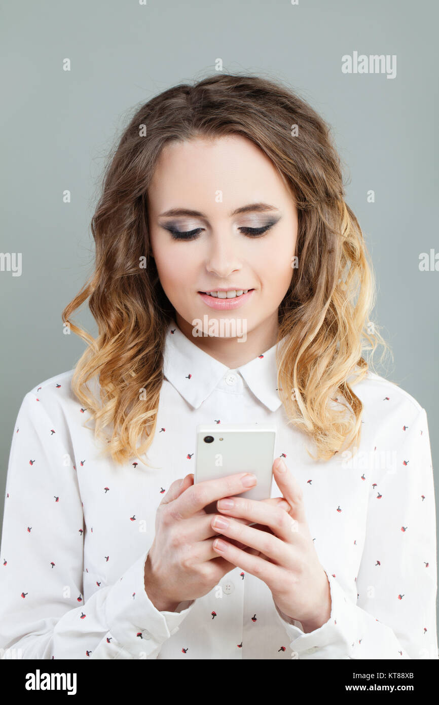 A Smiling Woman Looking at her Mobile Phone Stock Photo - Alamy