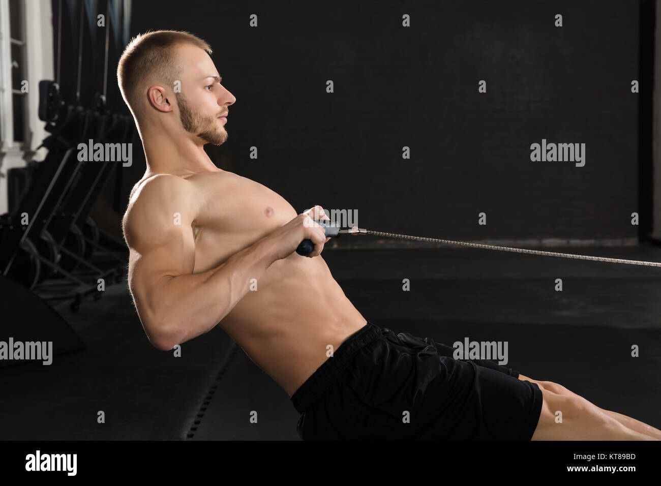 Young Man Exercising With Row Machine Stock Photo - Alamy