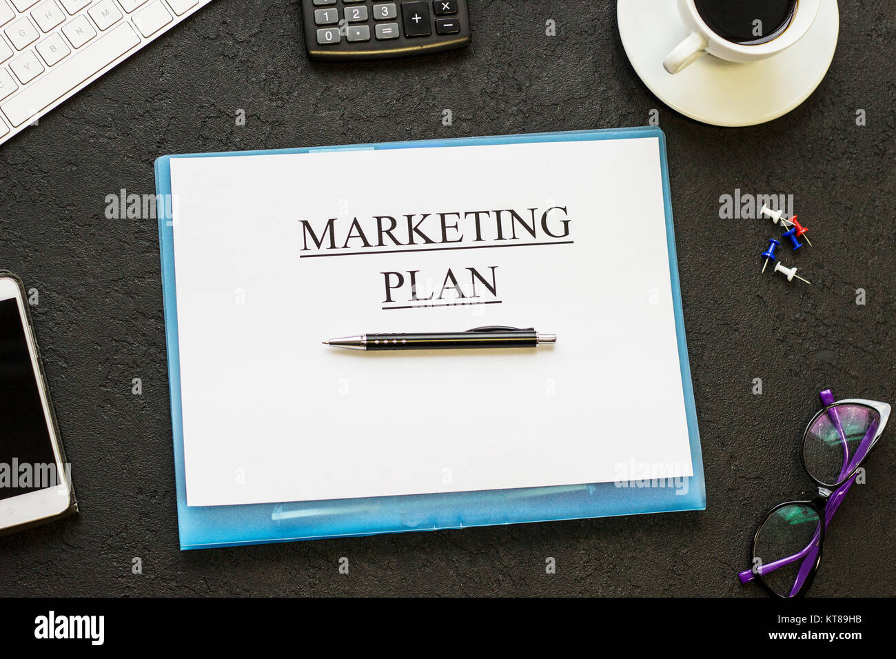Marketing plan inscription on a white paper in a frame of stationary on ...