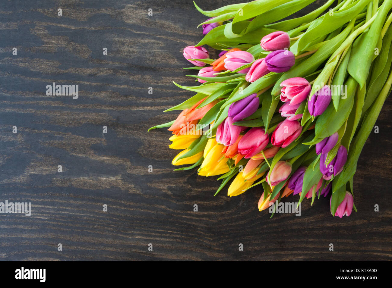 Strauss aus bunten Tulpen auf dunklem Hintergrund aus Holz Stock Photo ...