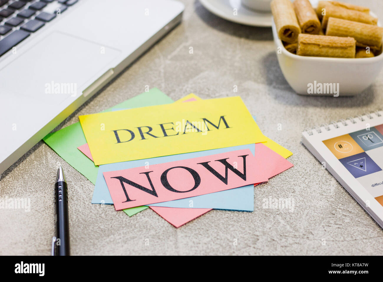 Dream now inscription printed on a concrete background with a laptop ...