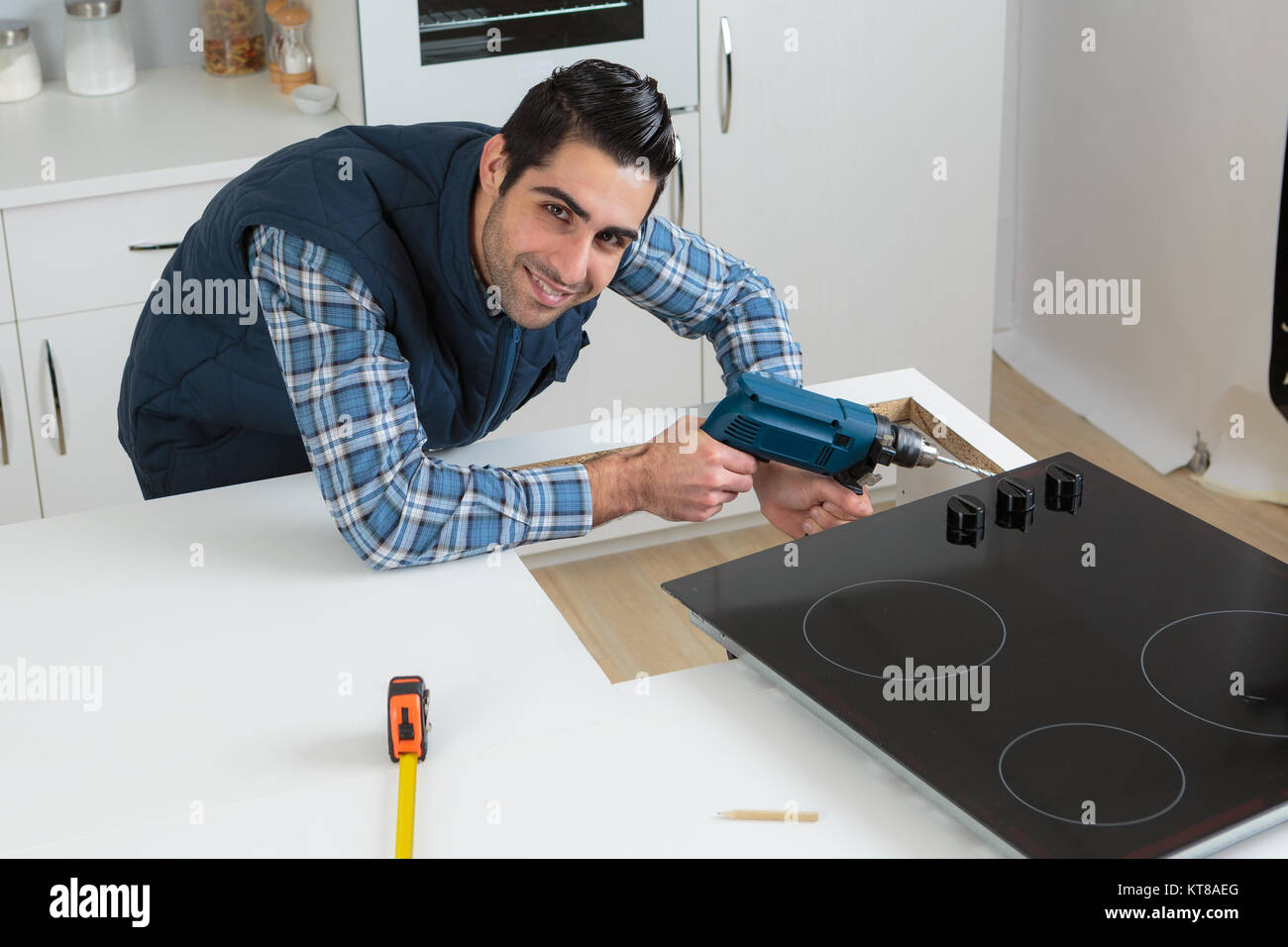 man fitting a kitchen stove Stock Photo - Alamy