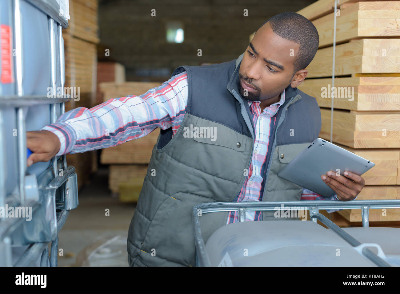 Worker holding tablet looking at vat Stock Photo - Alamy
