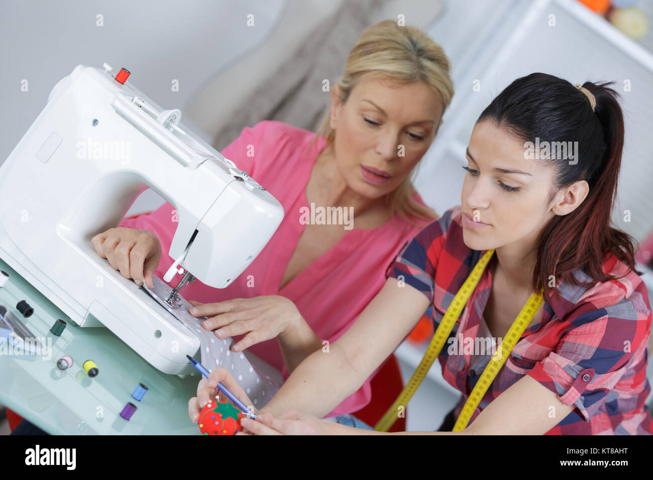 Mother and daughter using sewing machine Stock Photo - Alamy