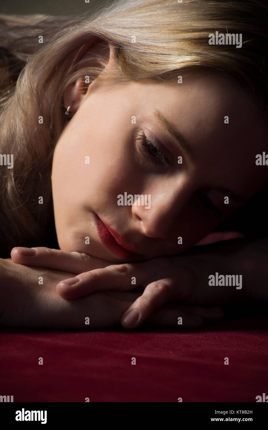 Sad woman laying down Stock Photo - Alamy