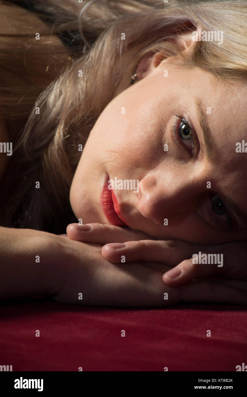 Sad woman laying down Stock Photo - Alamy