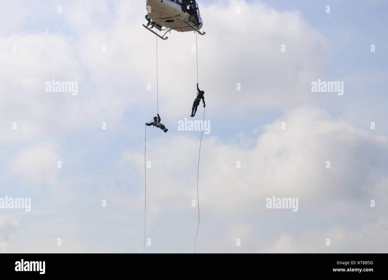 Soldier rappelling from helicopter in blue sky Stock Photo - Alamy