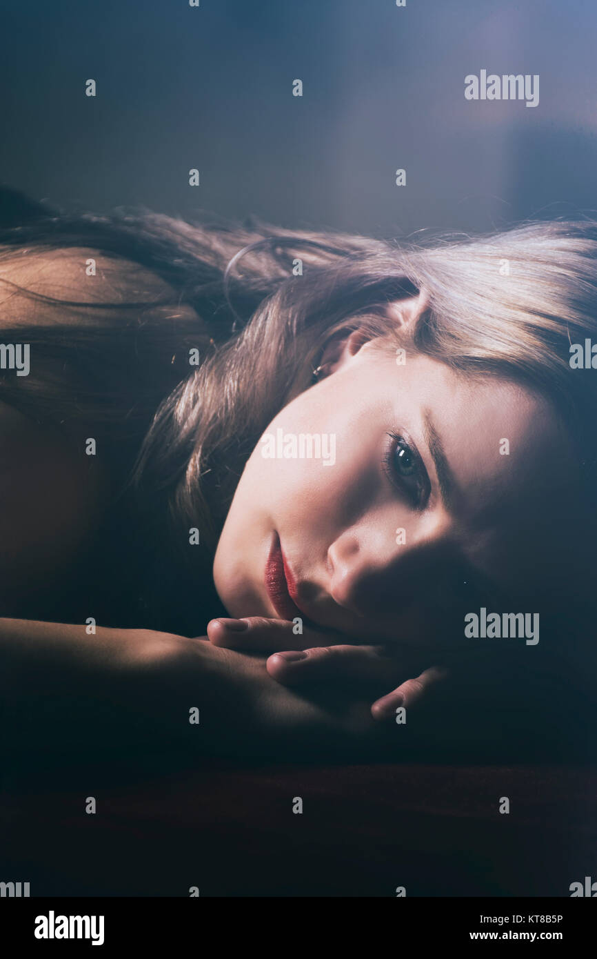 Sad woman laying down Stock Photo - Alamy