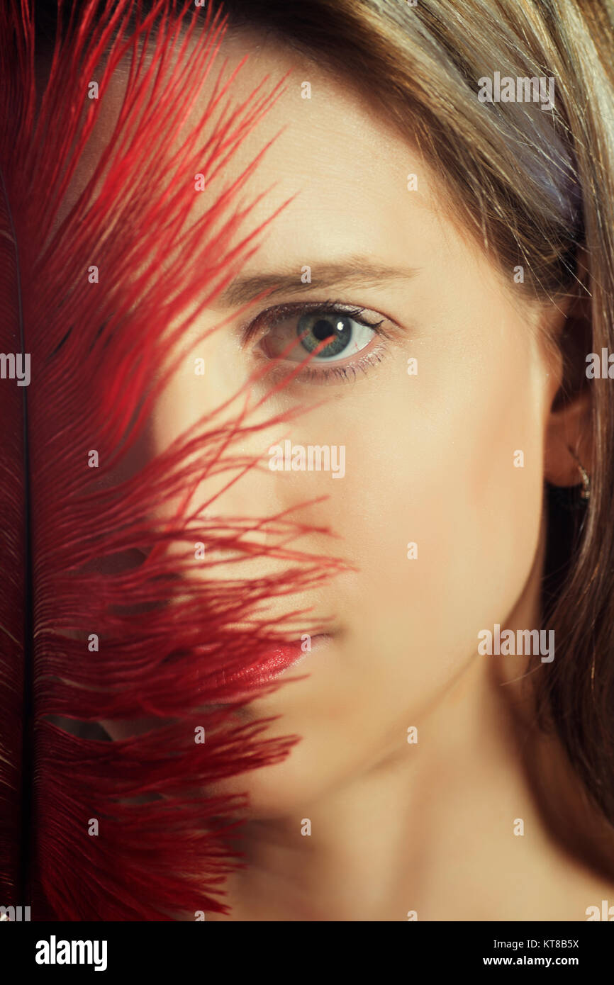 Close up portrait of a blond woman hiding face with ared feather Stock ...