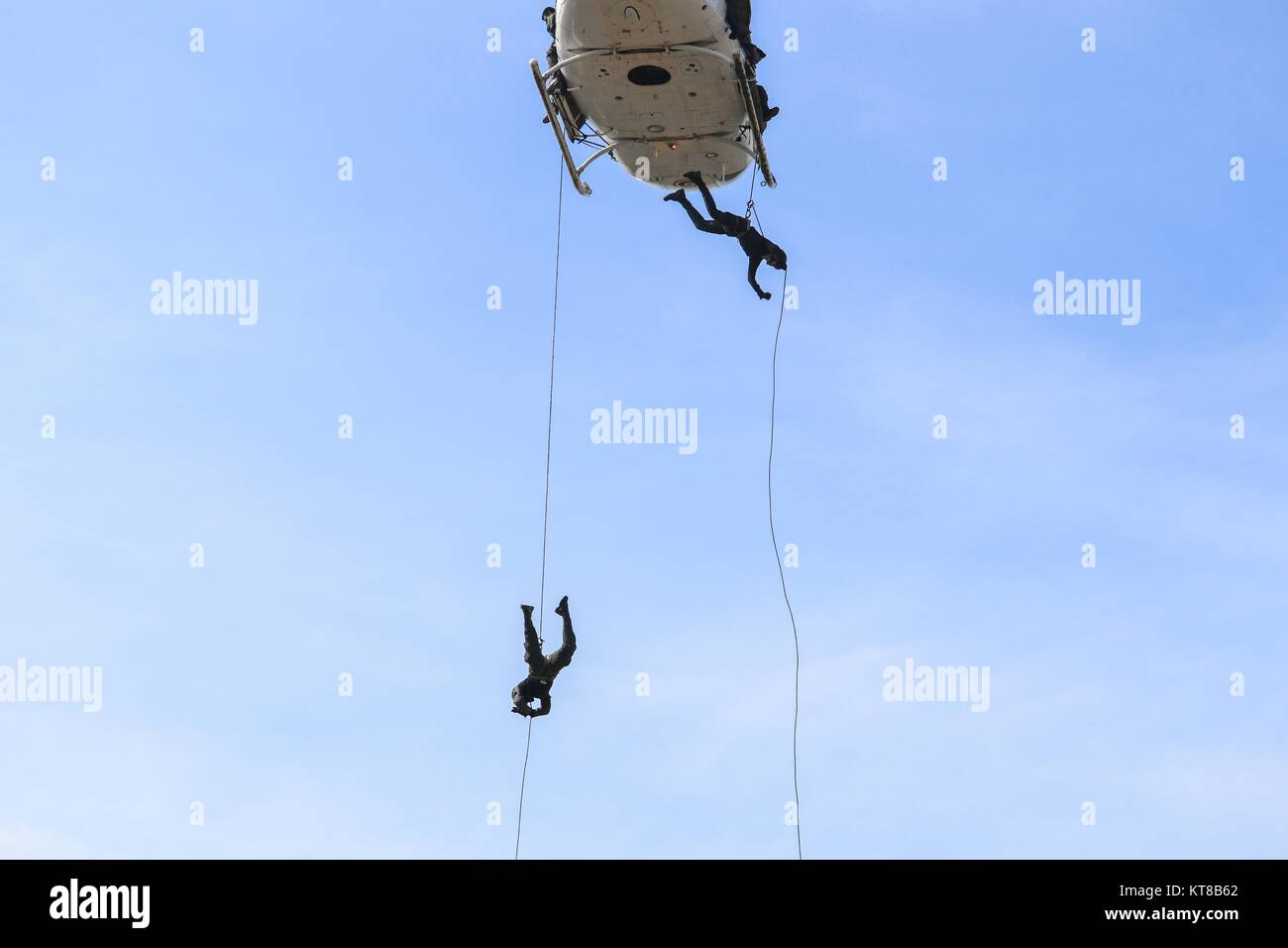 Soldier rappelling from helicopter in blue sky Stock Photo - Alamy