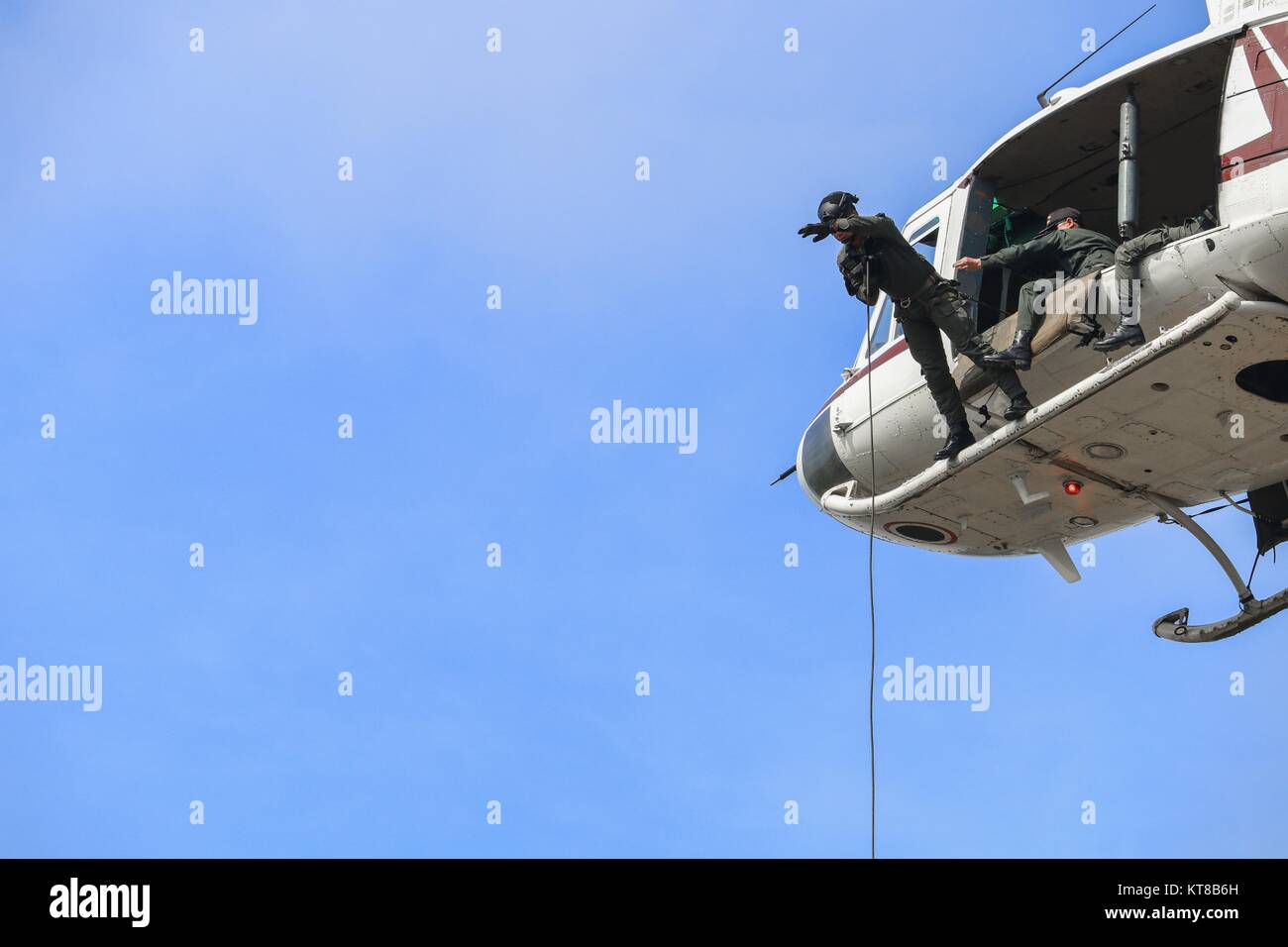 Soldier rappelling from helicopter in blue sky Stock Photo - Alamy