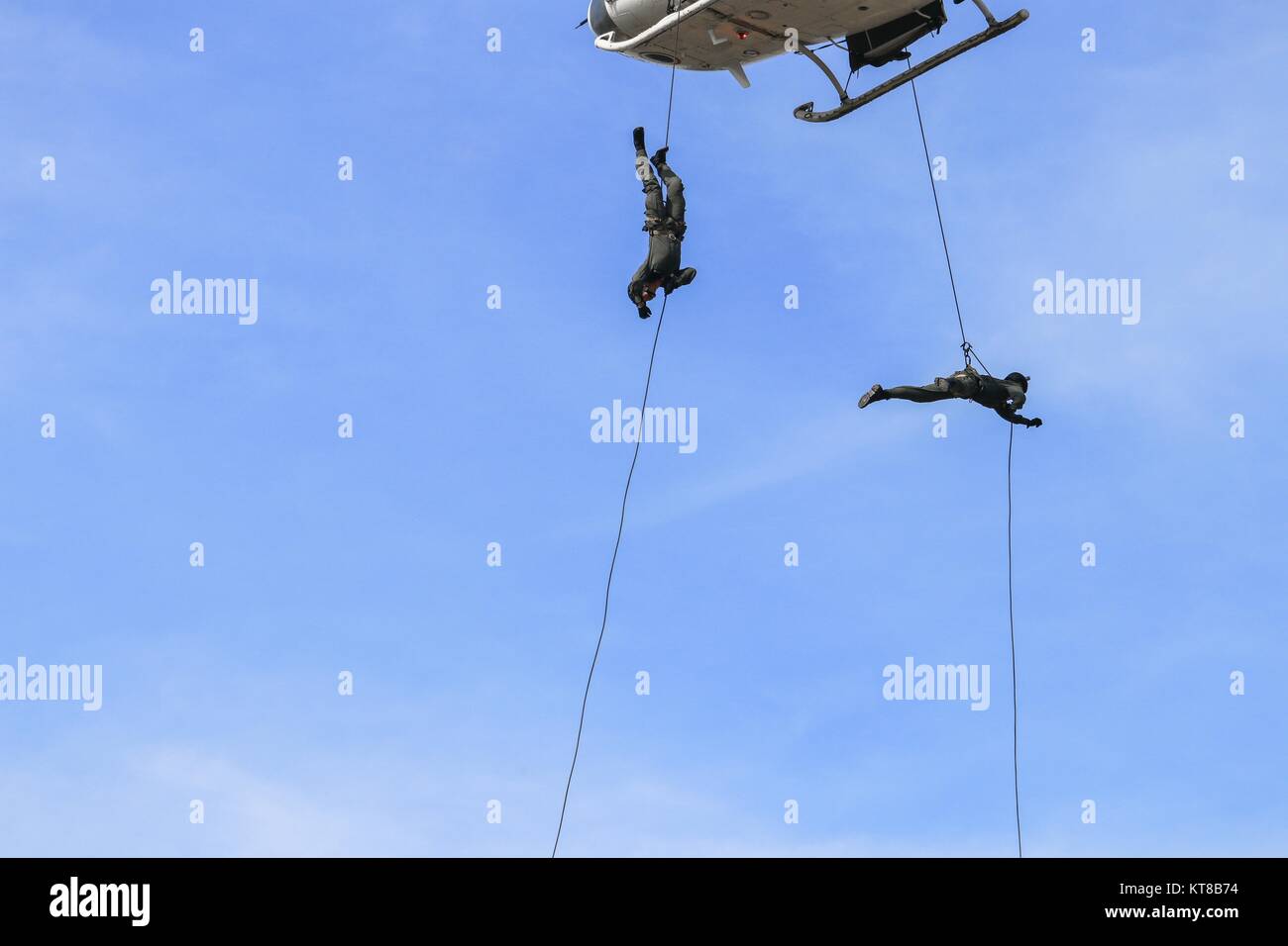 Soldier rappelling from helicopter in blue sky Stock Photo - Alamy