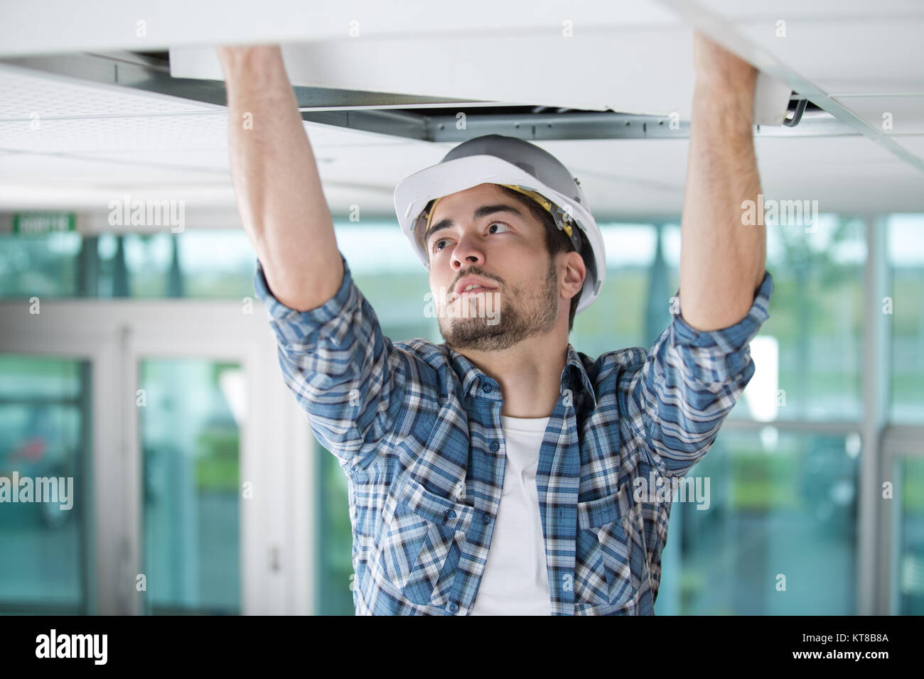 builder replacing ceiling panel Stock Photo - Alamy