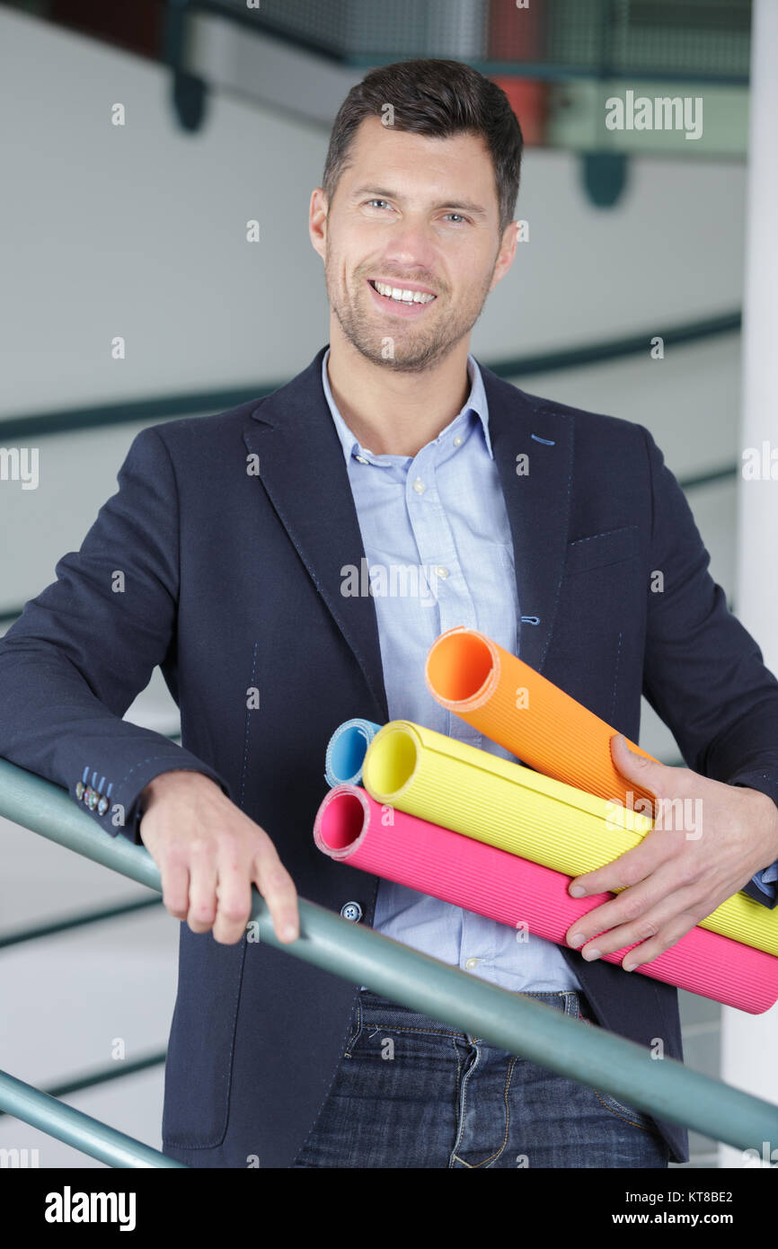 man holding roll of different colored papers Stock Photo - Alamy