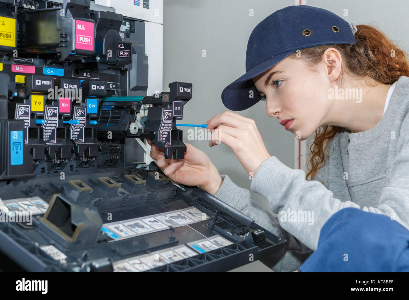 young woman fixing a printer Stock Photo - Alamy