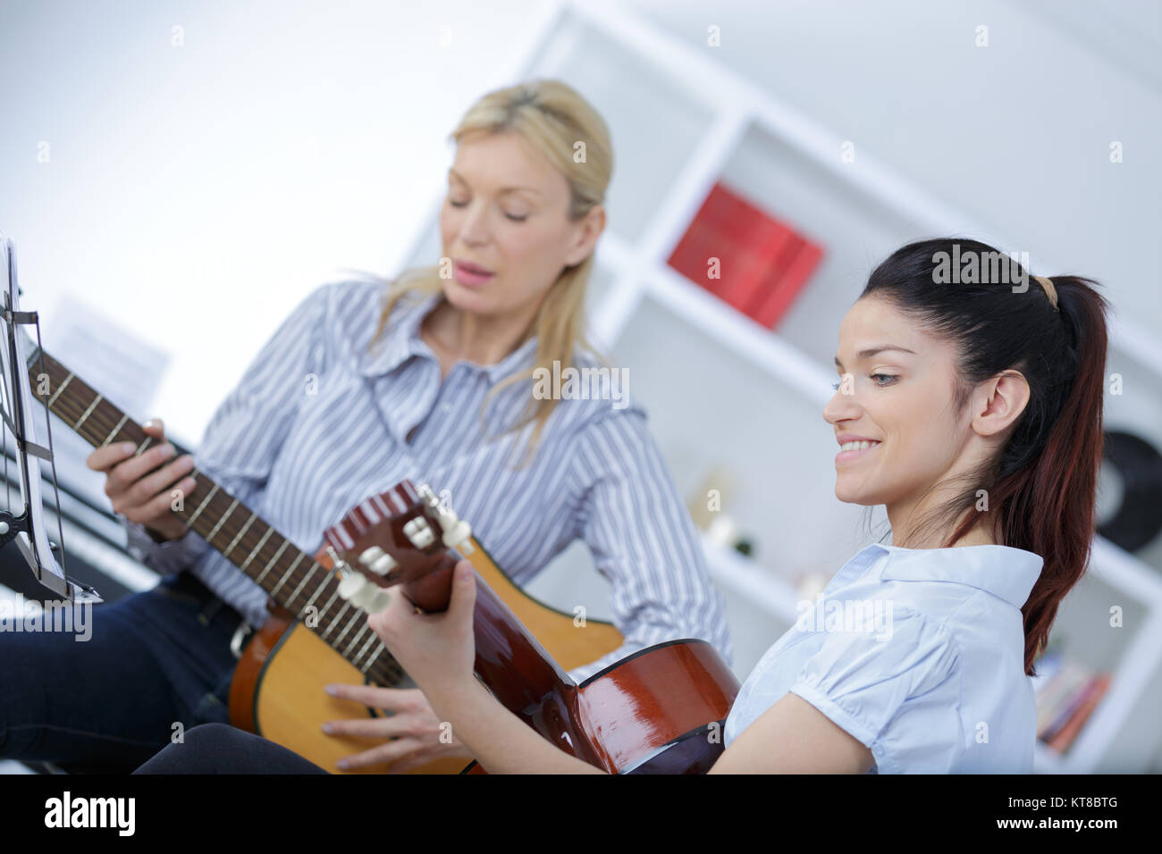 young woman learning to play guitar Stock Photo - Alamy