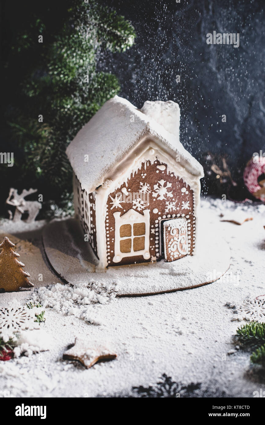 Homemade gingerbread house in mountains, fir tree and artificial snow ...
