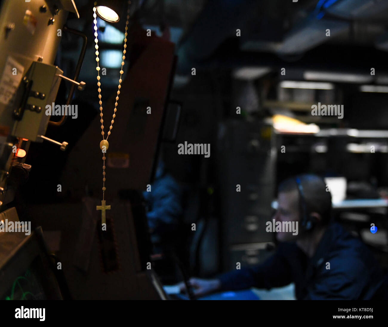 A rosary hangs off of a watch station in the Electronic Warfare Module ...