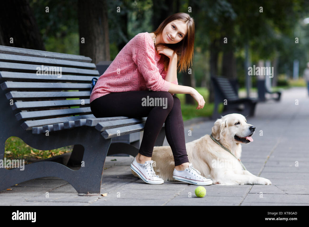 Picture of smiling woman sitting on bench, dog retriever on summer ...