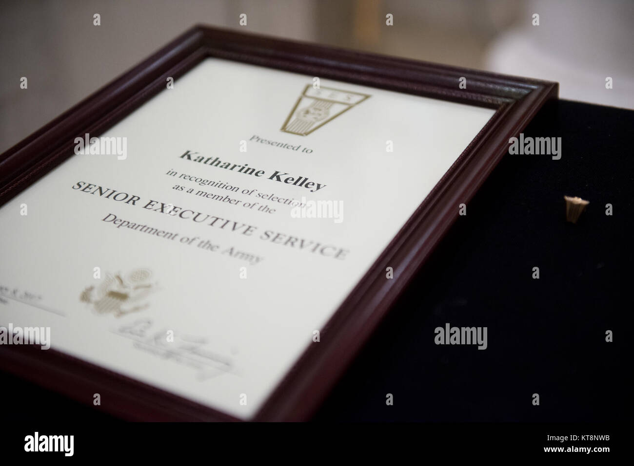 The Senior Executive Service certificate and SES pin is in place before ...