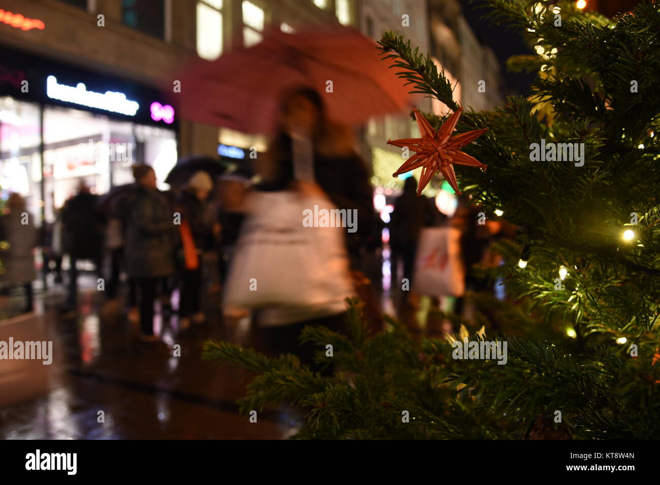 Munich, Germany. 21st Dec, 2017. Christmas shoppers (seen behind a tree ...