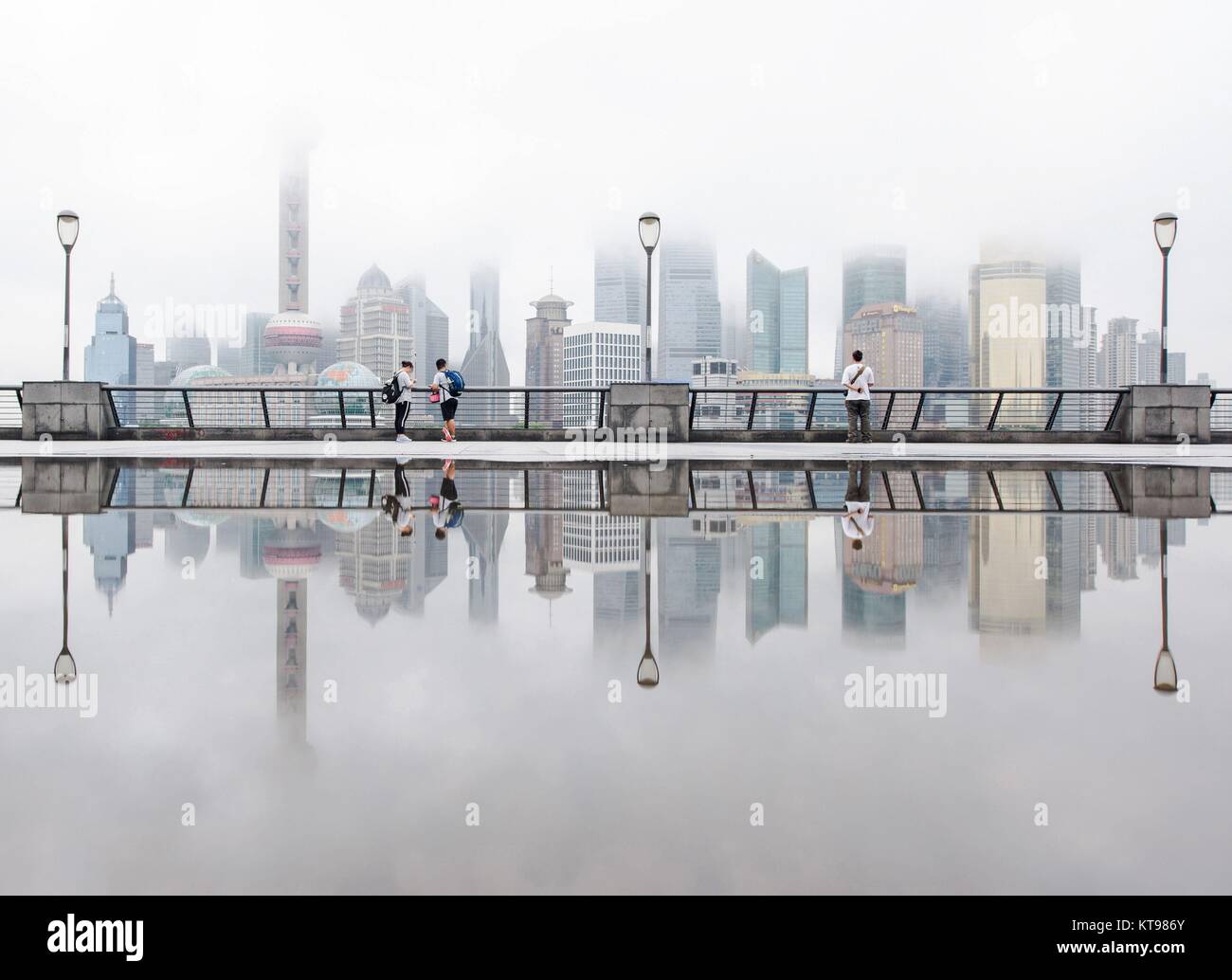 The financial district of Pudong ist reflected in a puddle at the ...