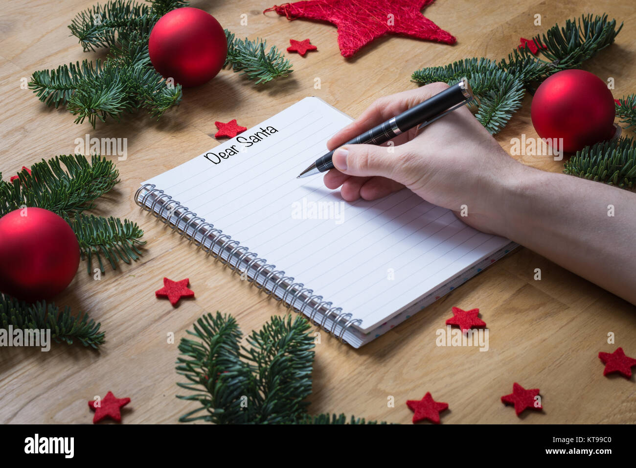 Writing Dear Santa on a notepad with Christmas decorations and fir ...