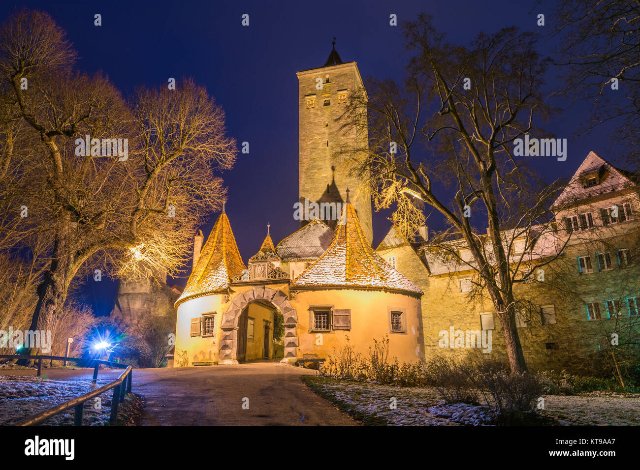 The lit historic castle gate and tower in Rothenburg ob der Tauber ...