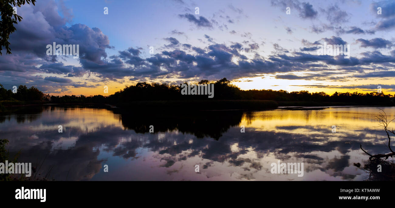 Beautiful sunrise with bright clouds reflected in water Stock Photo - Alamy